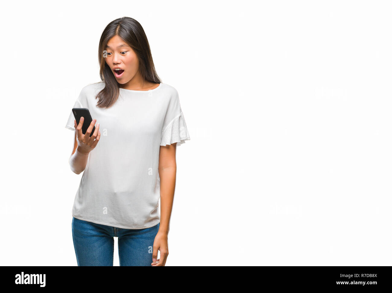 Young asian woman texting using smartphone over isolated background ...