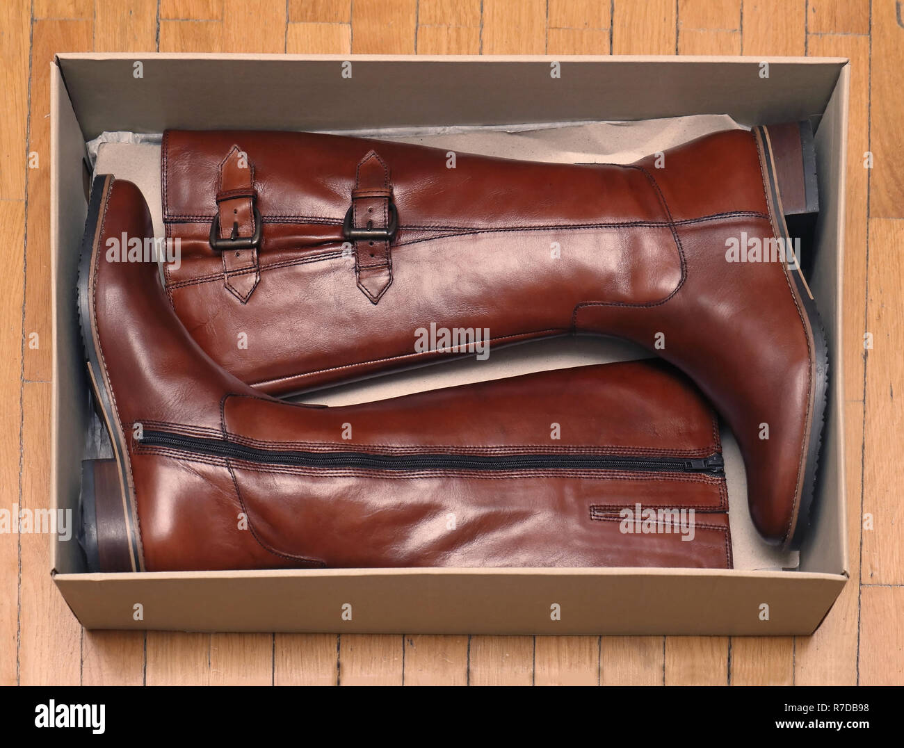 New brown leather modern female boots inside box on wooden floor Stock ...