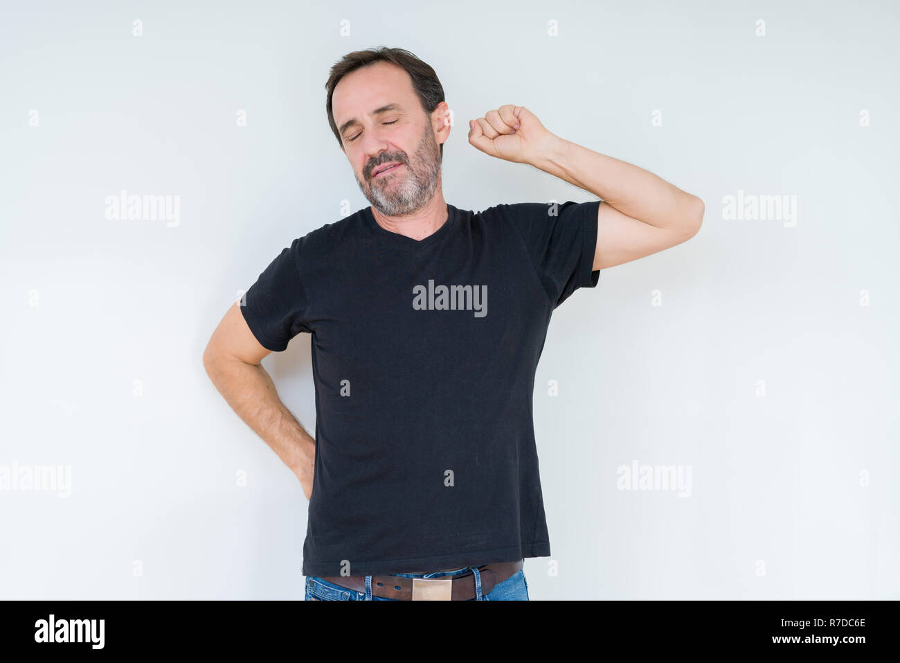 Senior man over isolated background stretching back, tired and relaxed ...