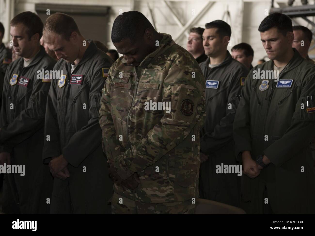 Service members bow their heads in prayer for an invocation given ...