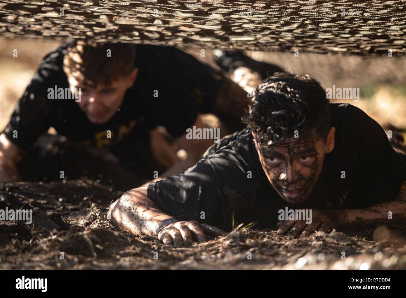Soldiers low crawl through the mud at the Marne Mudder obstacle course ...