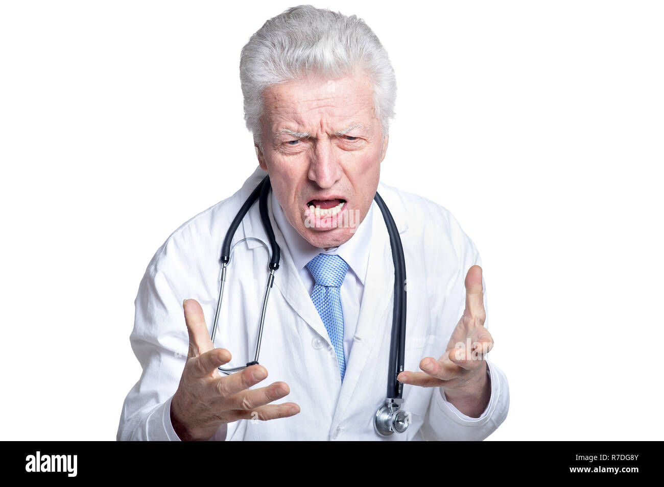 Portrait of angry senior male doctor posing against white background ...