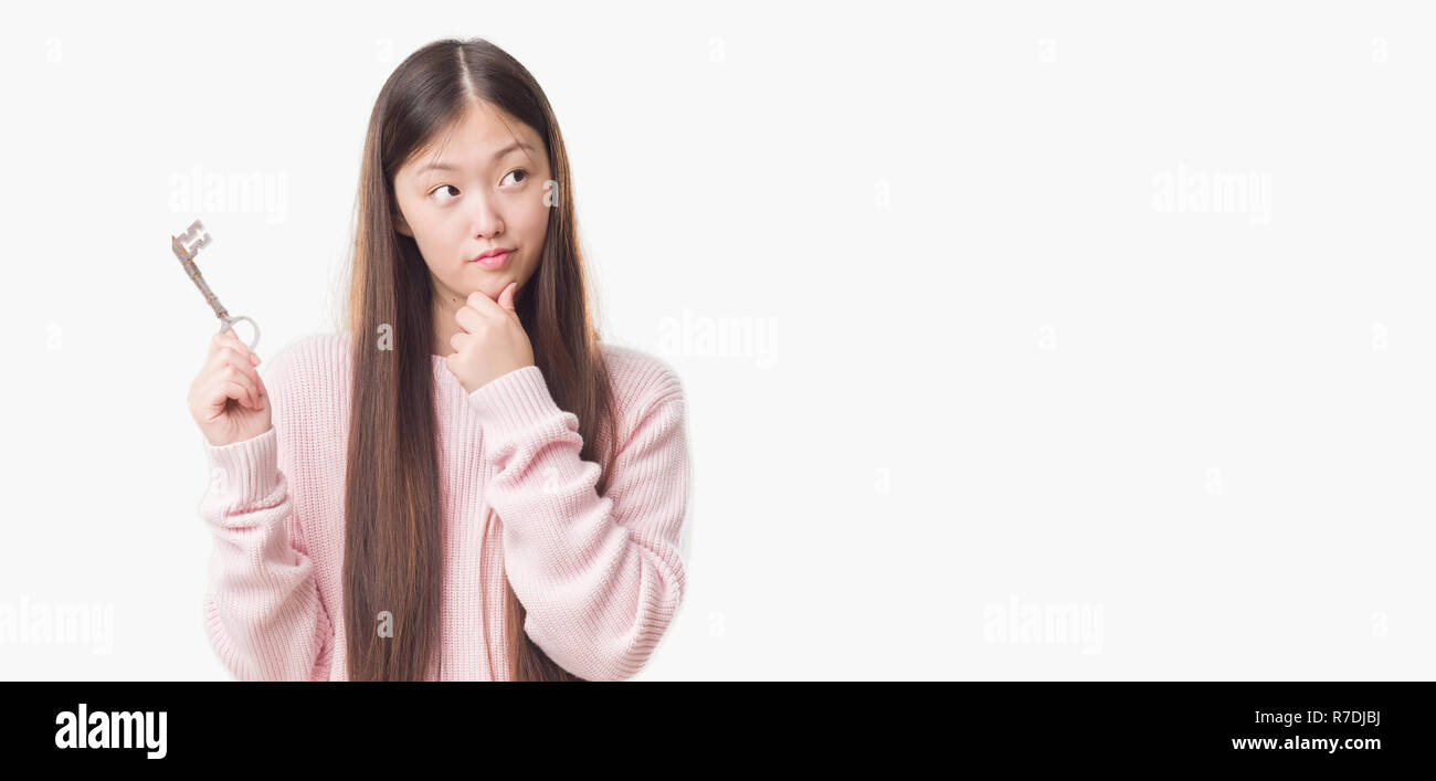 Young Chinese real state agent woman over isolated background holding ...