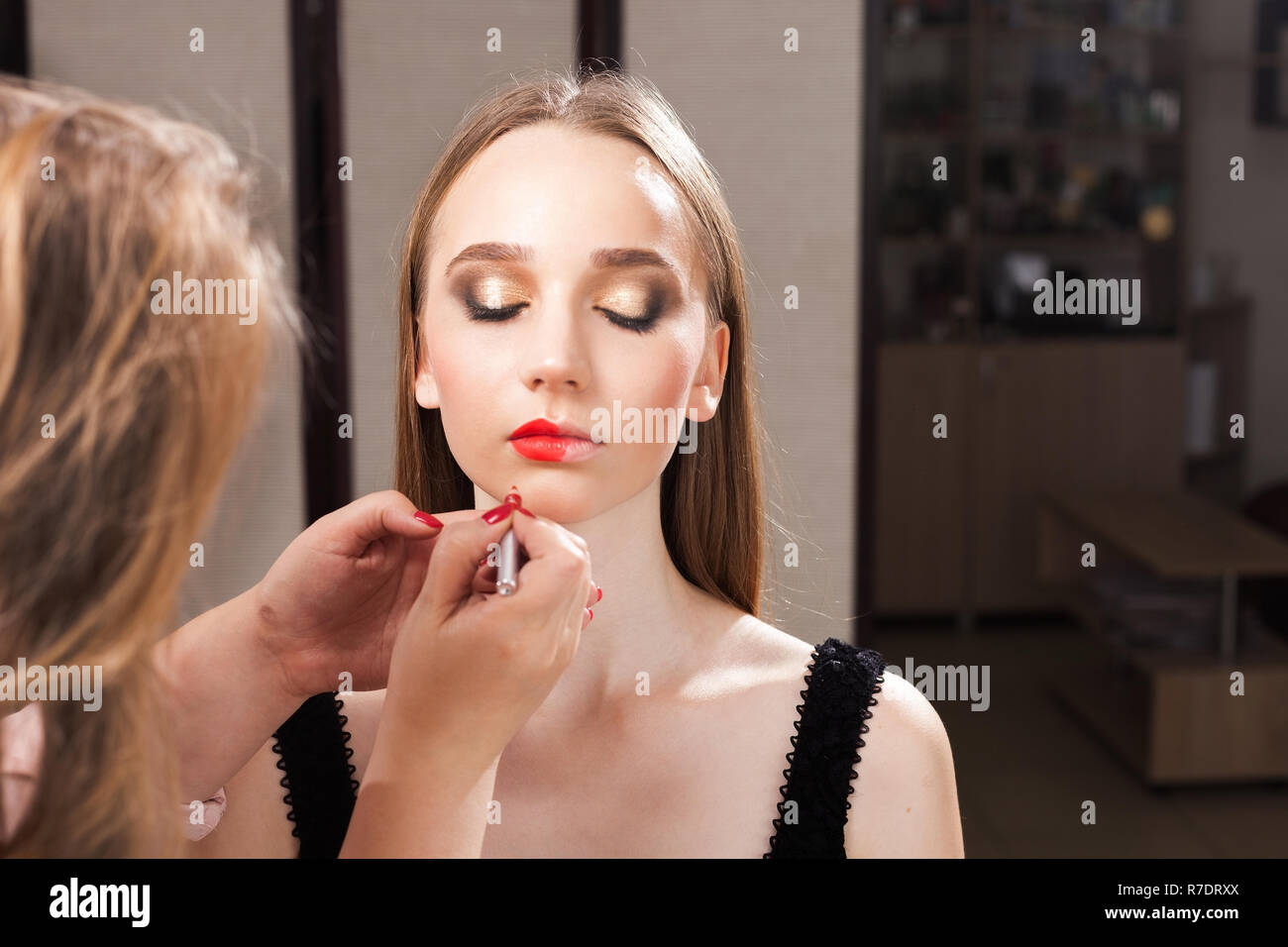makeup artist applying lipstick on a client Stock Photo - Alamy