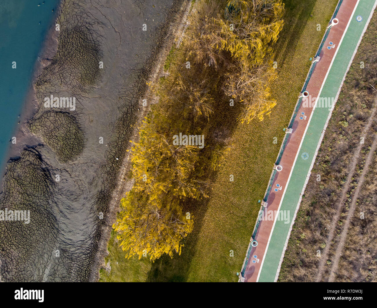 Aerial view of walking and cycling path on the riverside near trees ...