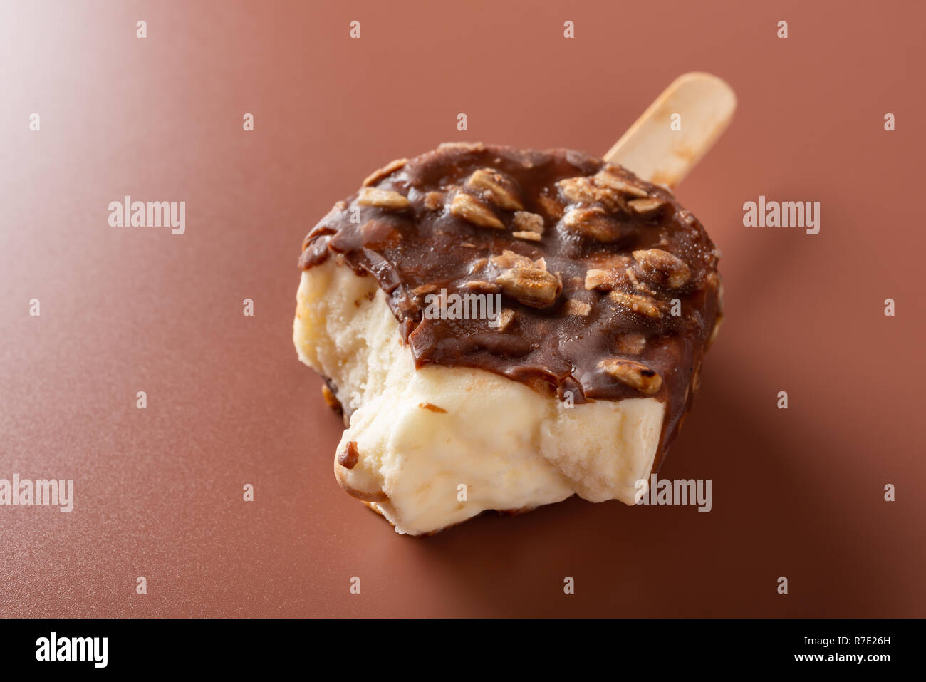 side view chocolate outer ice cream with peanuts on a brown background ...