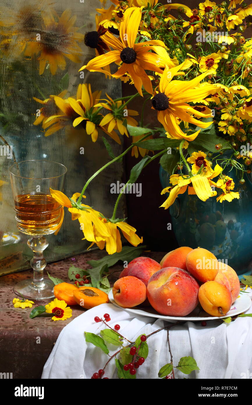 Still life with yellow flowers and apricots Stock Photo - Alamy