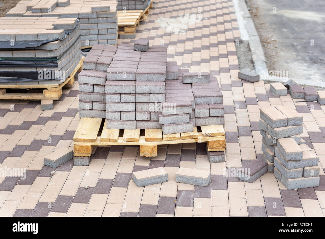 Row of stacks of gray pavement slab on wooden base . Concrete stone ...