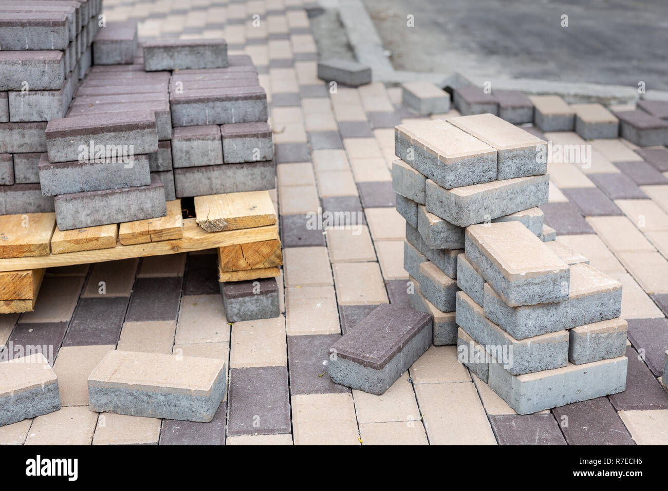 Row of stacks of gray pavement slab on wooden base . Concrete stone ...