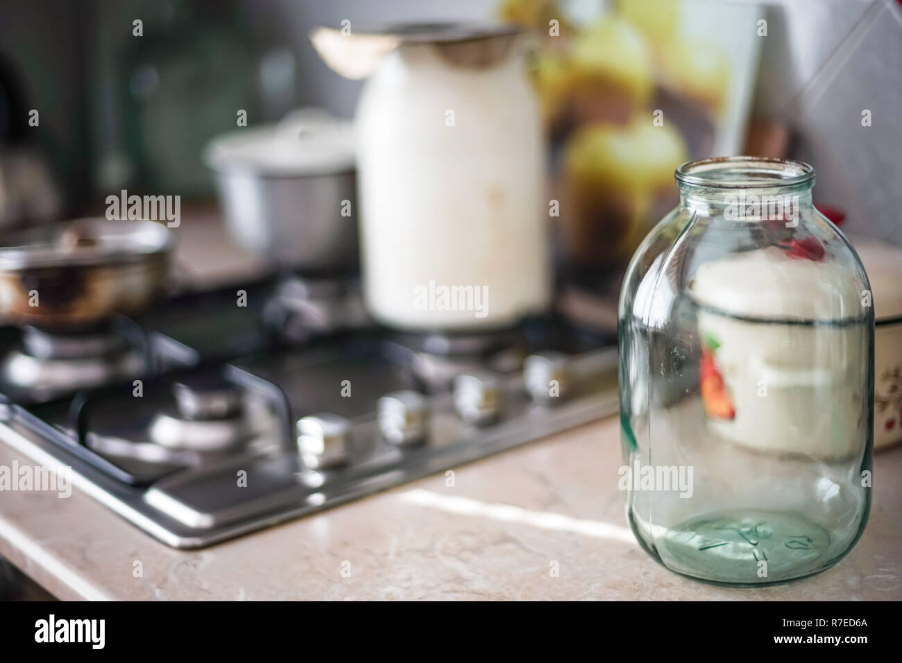Empty three-liter jar stands on the tabletop against the background of ...