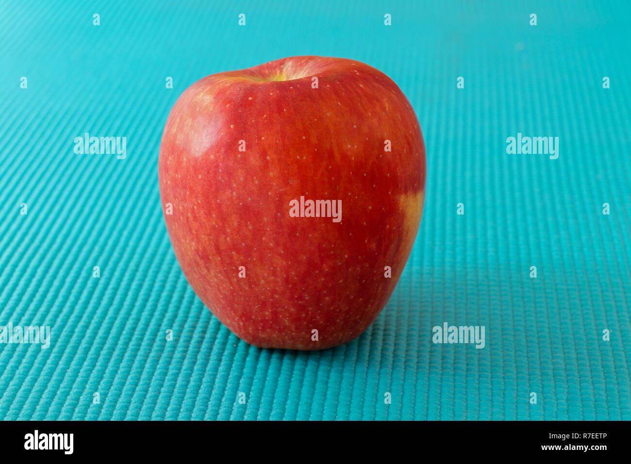 Red apple on sky blue texture surface Stock Photo - Alamy