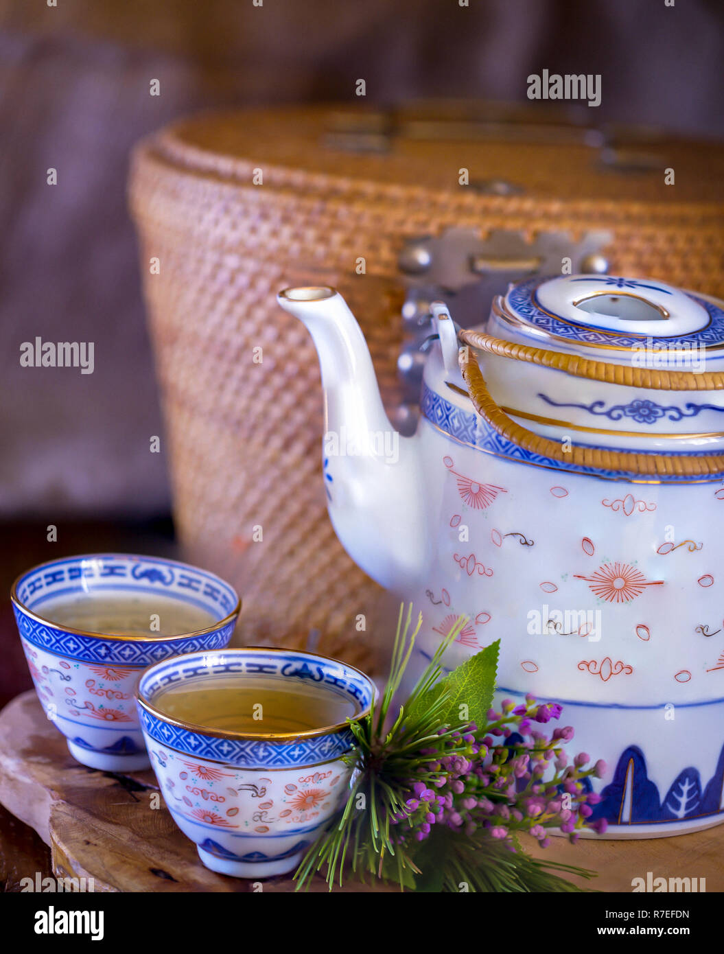 Porcelain Chinese Tea pot with its holding basket in the background ...