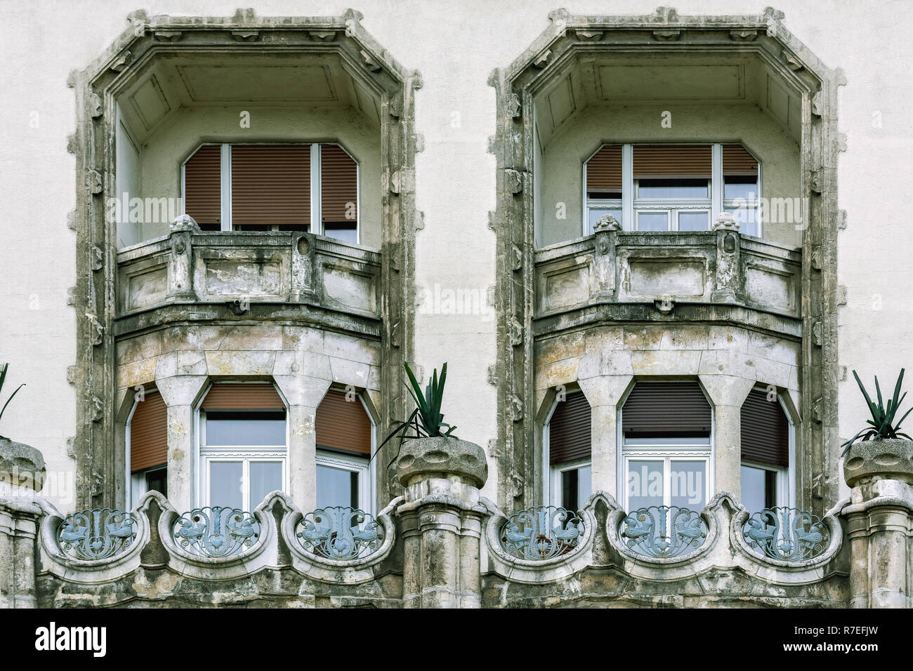 Two Windows in an old house with a mezzanine and a loggia and a fence ...
