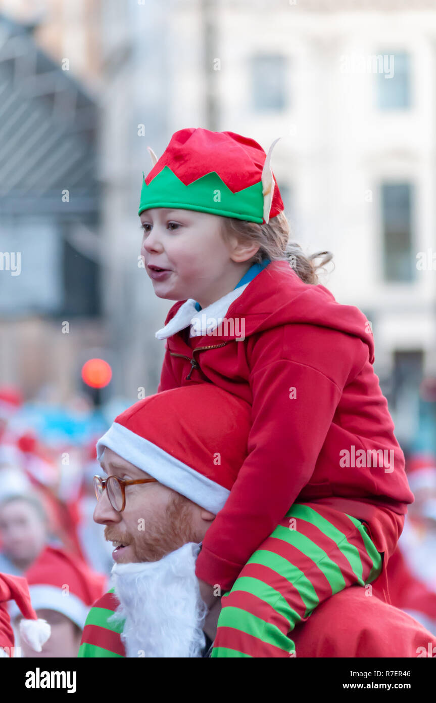 Glasgow, Scotland, UK. 9th December, 2018: An adult Santa carrying a ...