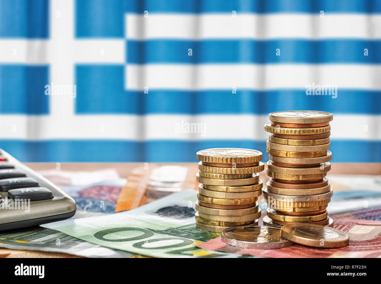 Euro banknotes and coins in front of the national flag of Greece Stock ...