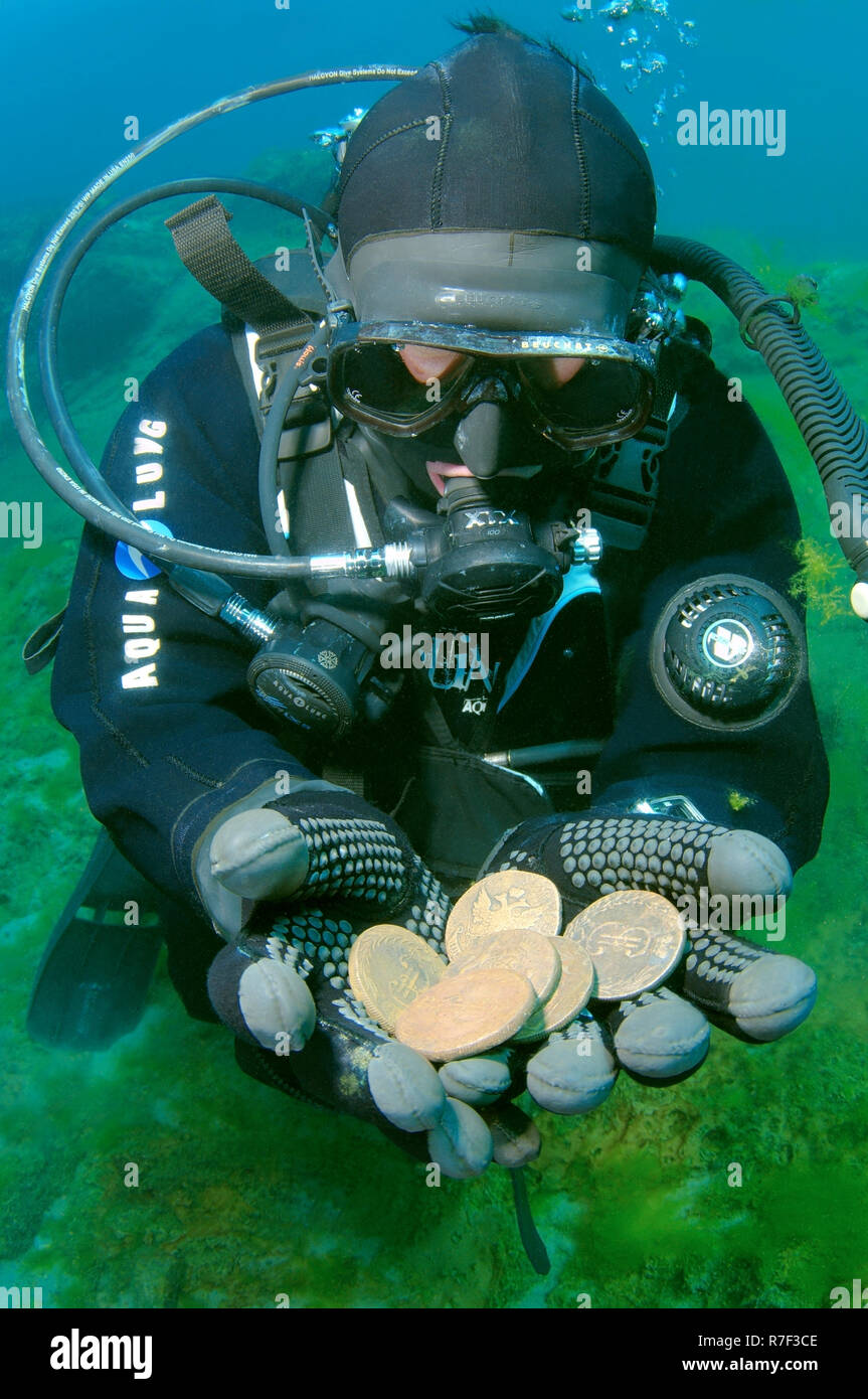 Scuba diver presenting some underwater treasure, Russian coins from the ...