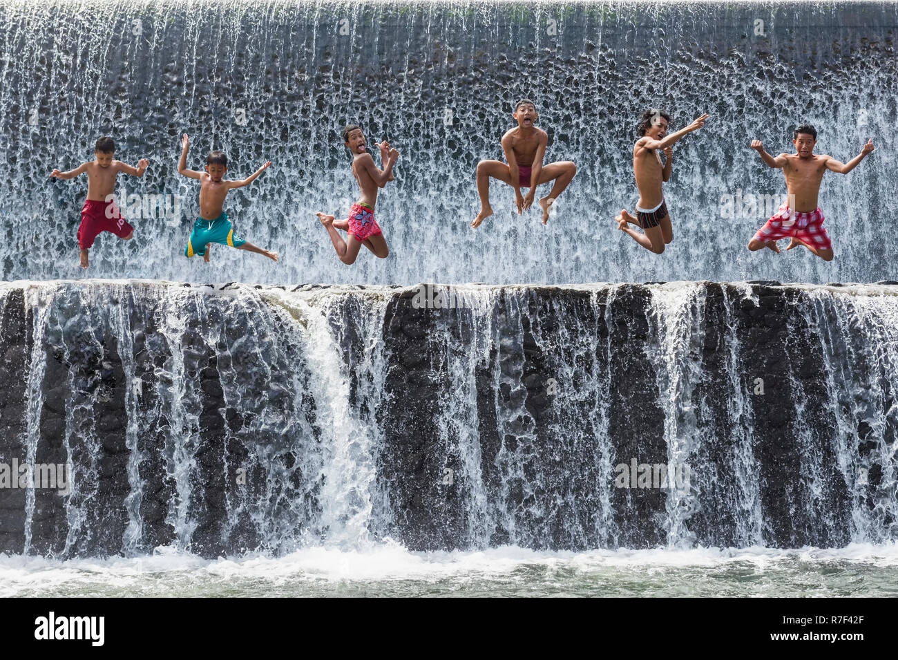 Boys jumping in a waterfall and having fun, Bali, Indonesia Stock Photo ...