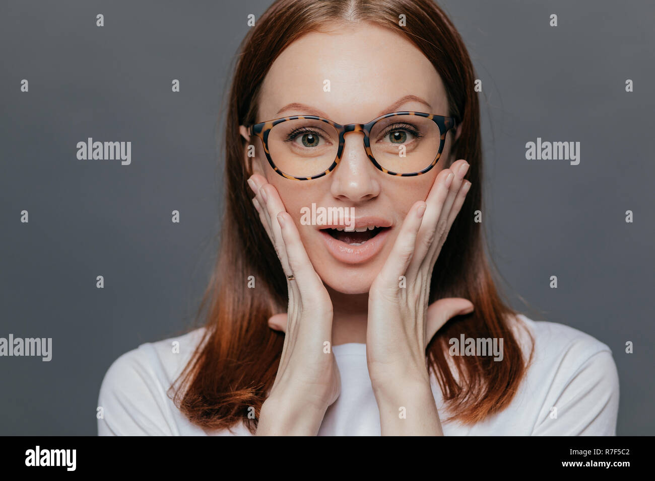 Headshot of surprised young Caucasian lady keeps both palms on her ...