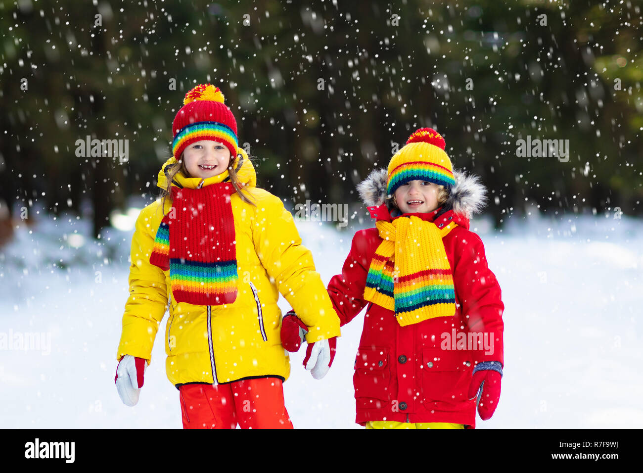 Kids playing in snow. Children play outdoors on snowy winter day. Boy ...
