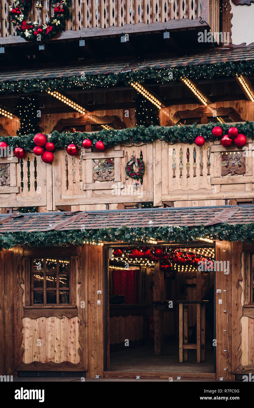 Illuminated Christmas fairground with wooden kiosk with a lot of bright ...