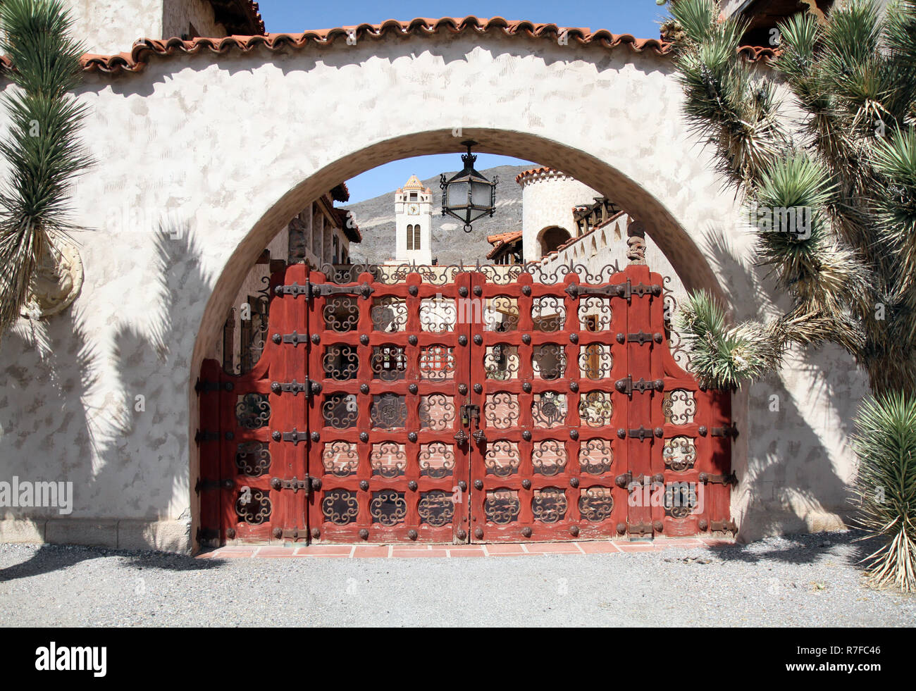 ornate red wooden gate inside stone plastered arch with terra cotta ...