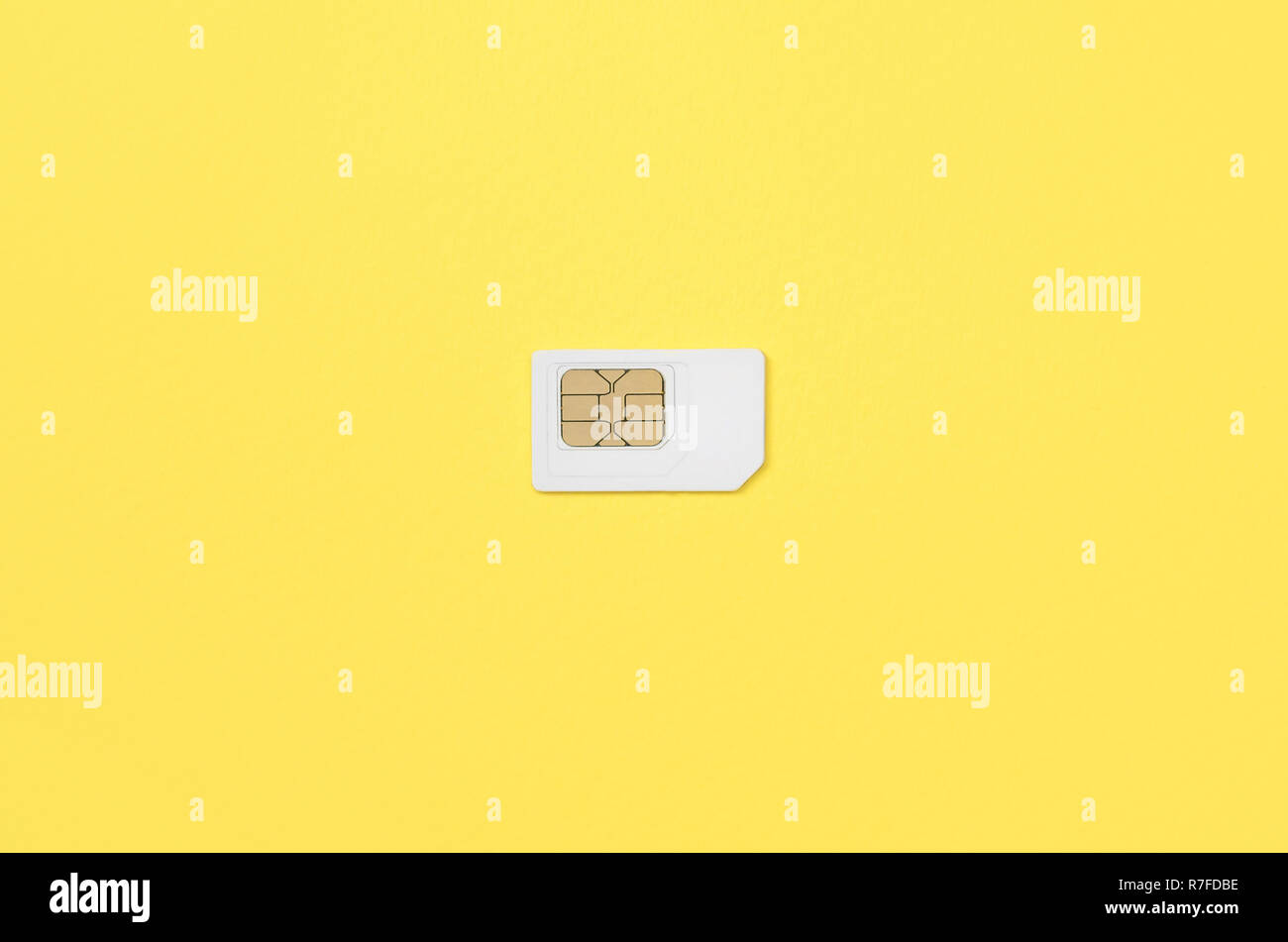 Subscriber identity module. New white SIM card on bright yellow color ...