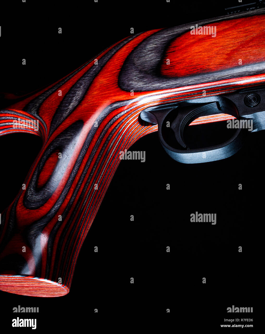 Grip and trigger on a rifle with red wood for a stock Stock Photo - Alamy