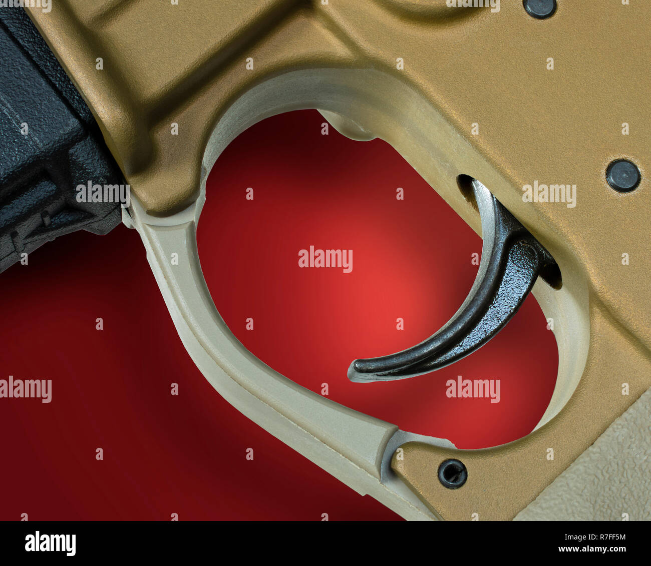 Trigger on a copper colored AR-15 with red and its shadow behind Stock ...