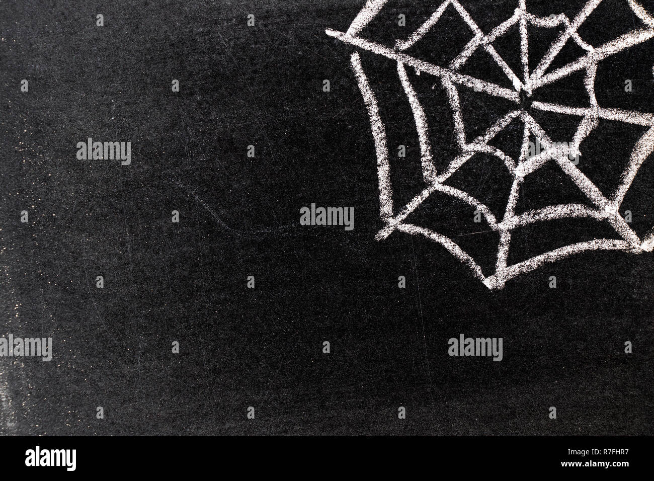White chalk hand drawing in spiderweb shape on blackboard background ...