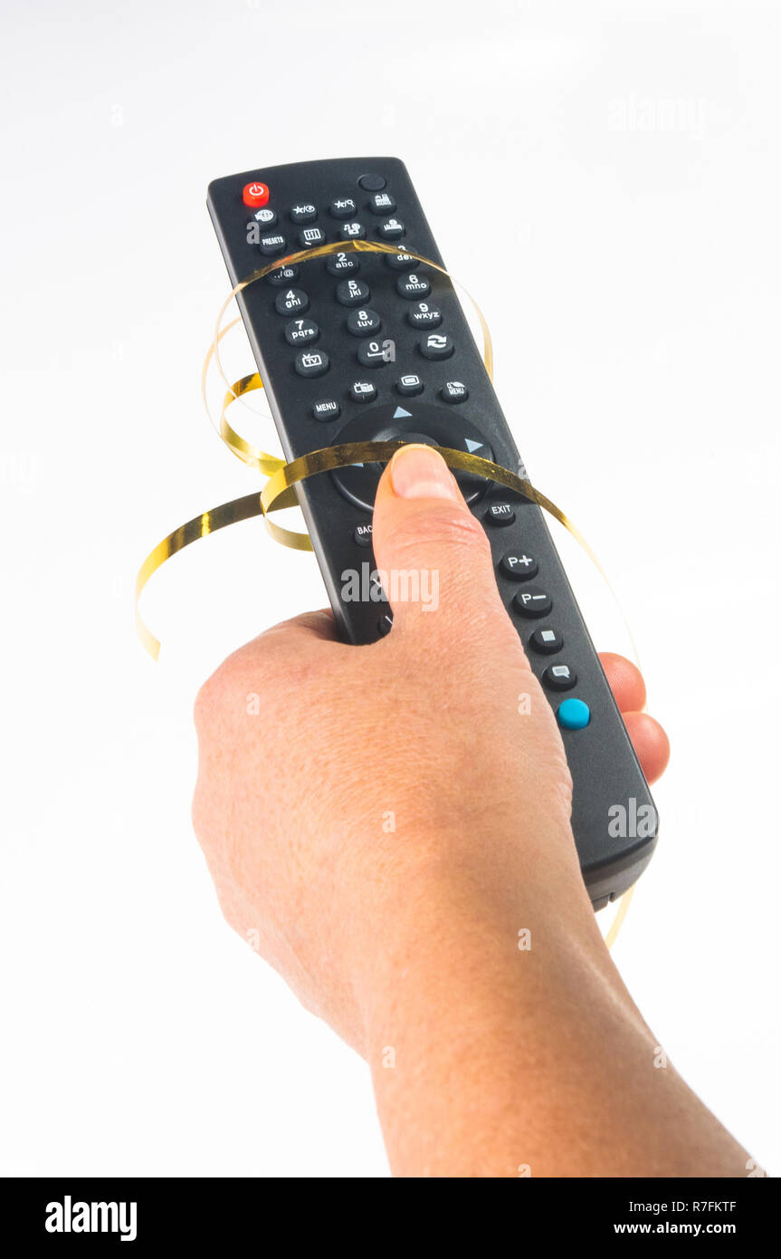 hand holding a remote control in a festive gold ribbon on white ...