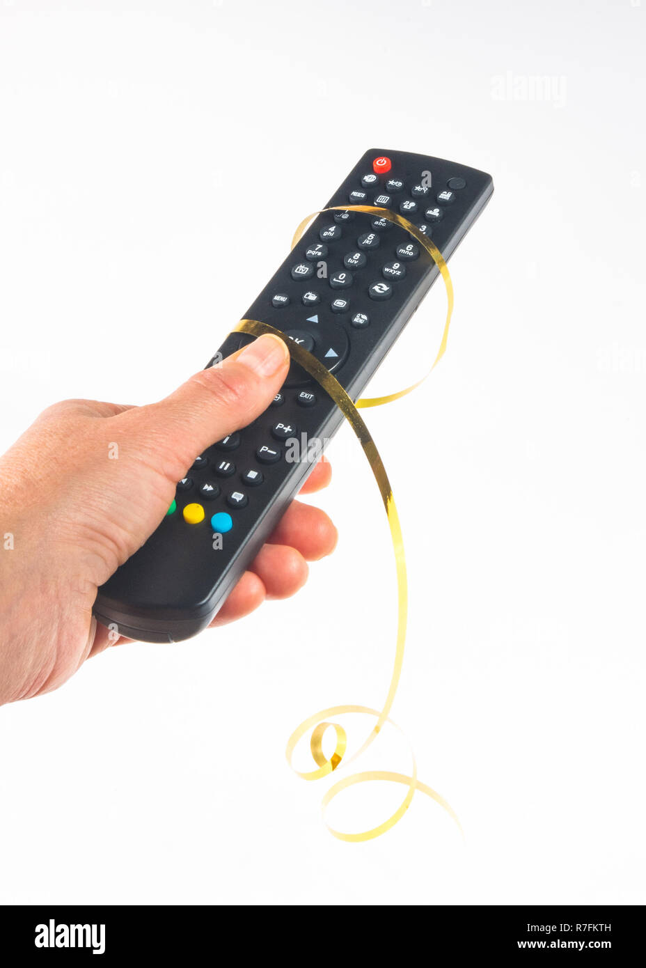 hand holding a remote control in a festive gold ribbon on white ...