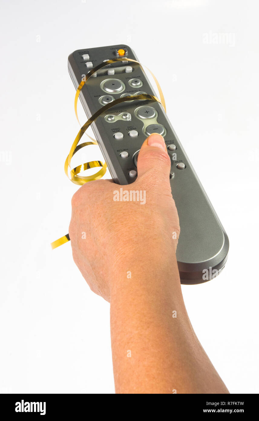 hand holding a remote control in a festive gold ribbon on white ...