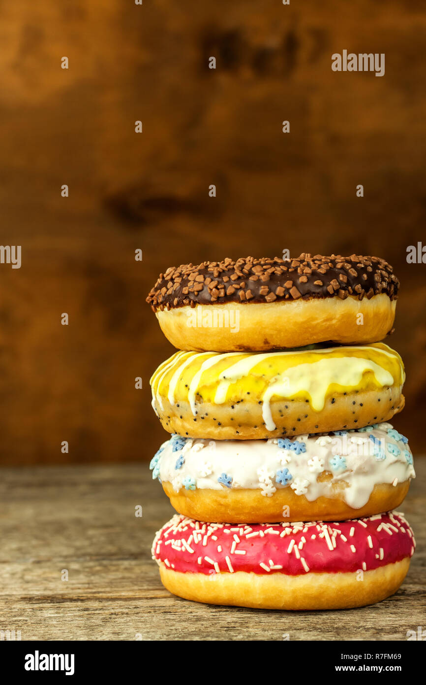 Unhealthy food. Donuts on a wooden table. Dangers of obesity and ...