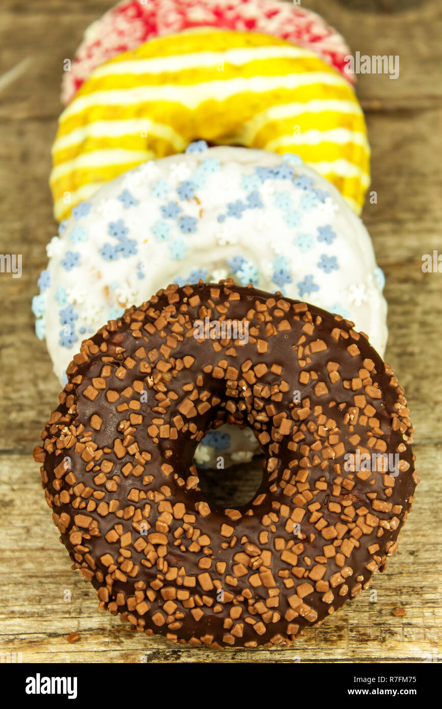 Unhealthy food. Donuts on a wooden table. Dangers of obesity and ...