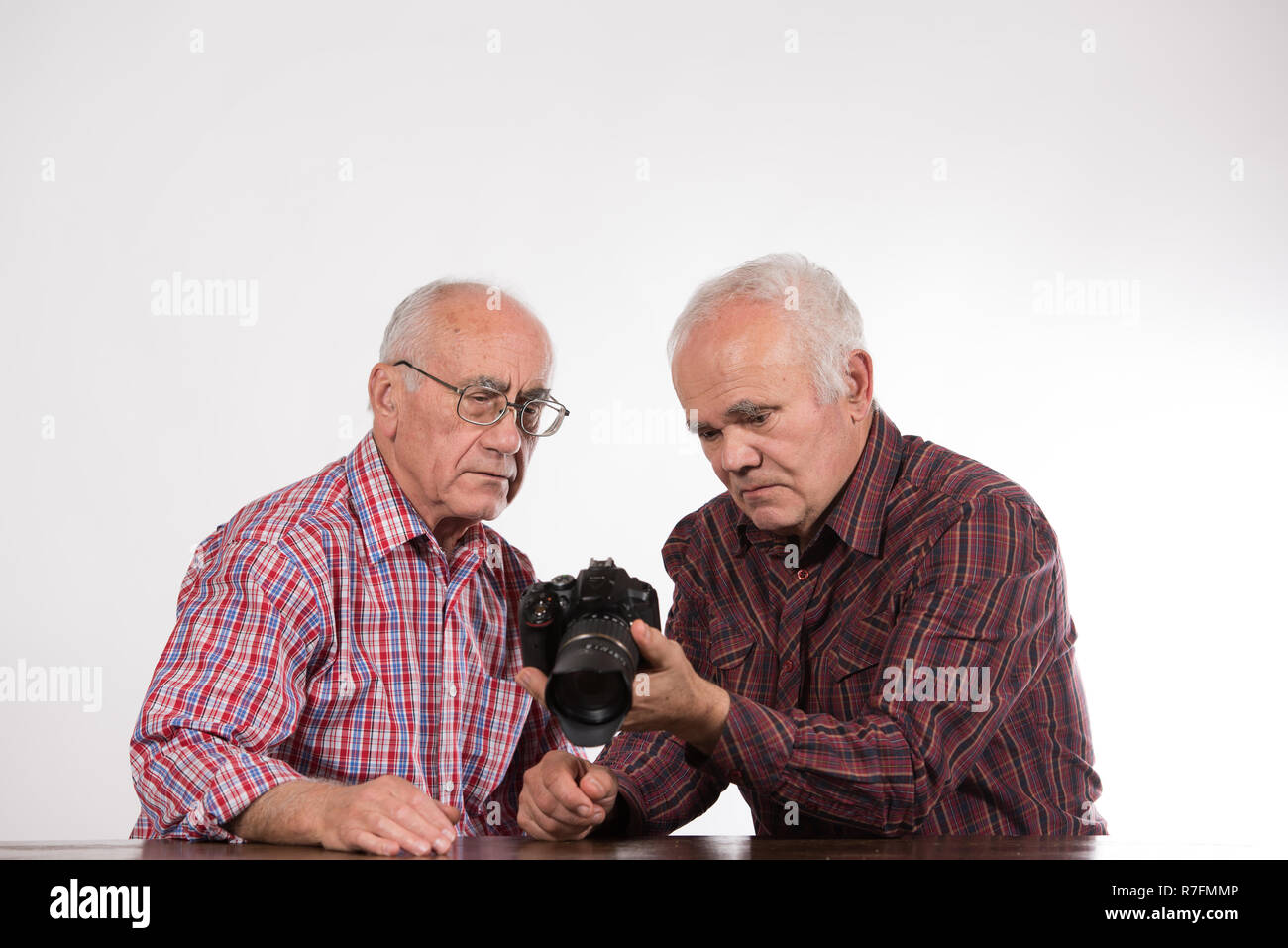 two elderly men with dslr camera looking at display Stock Photo - Alamy