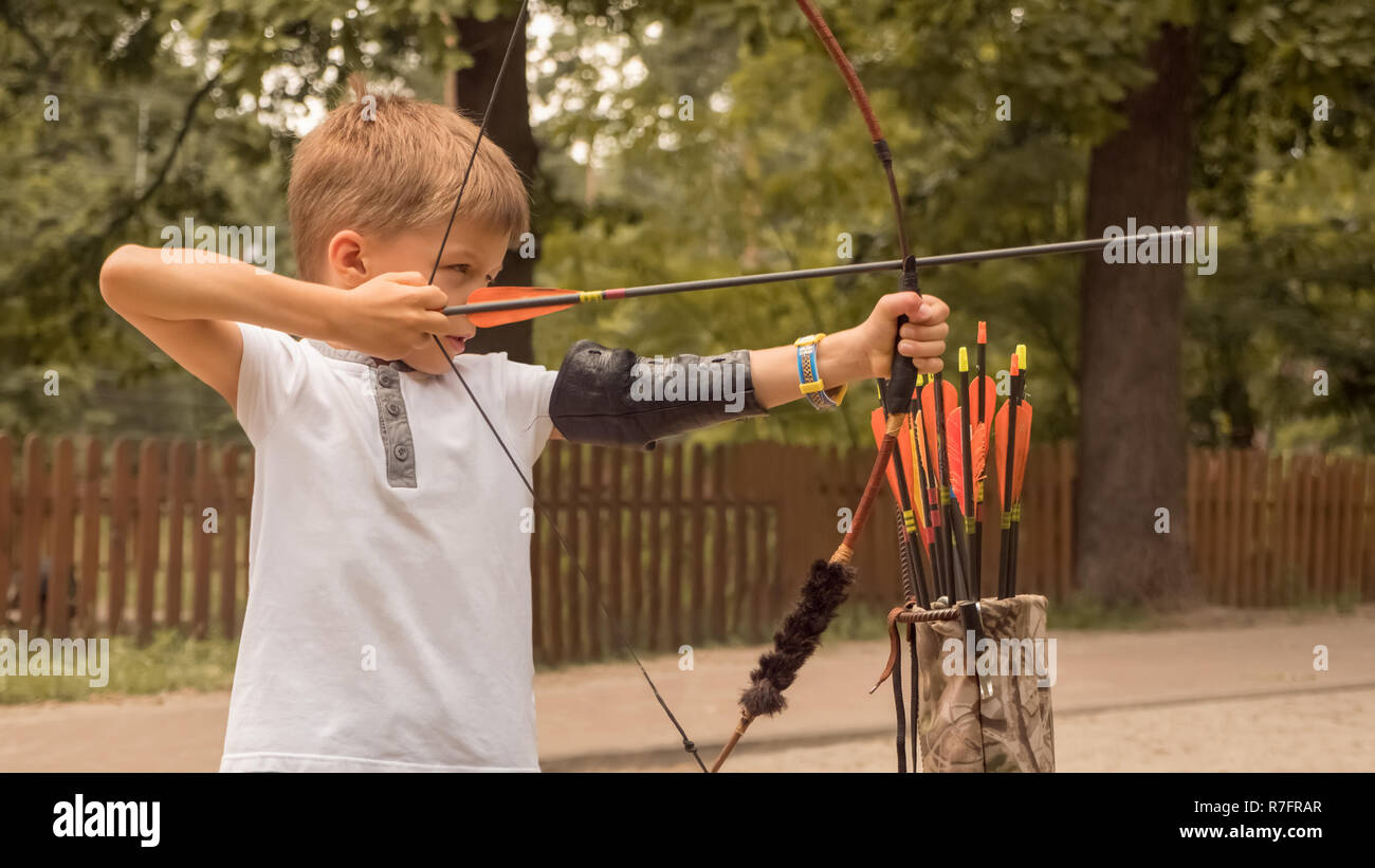 Boy with a bow and arrow. Bowman background Stock Photo - Alamy