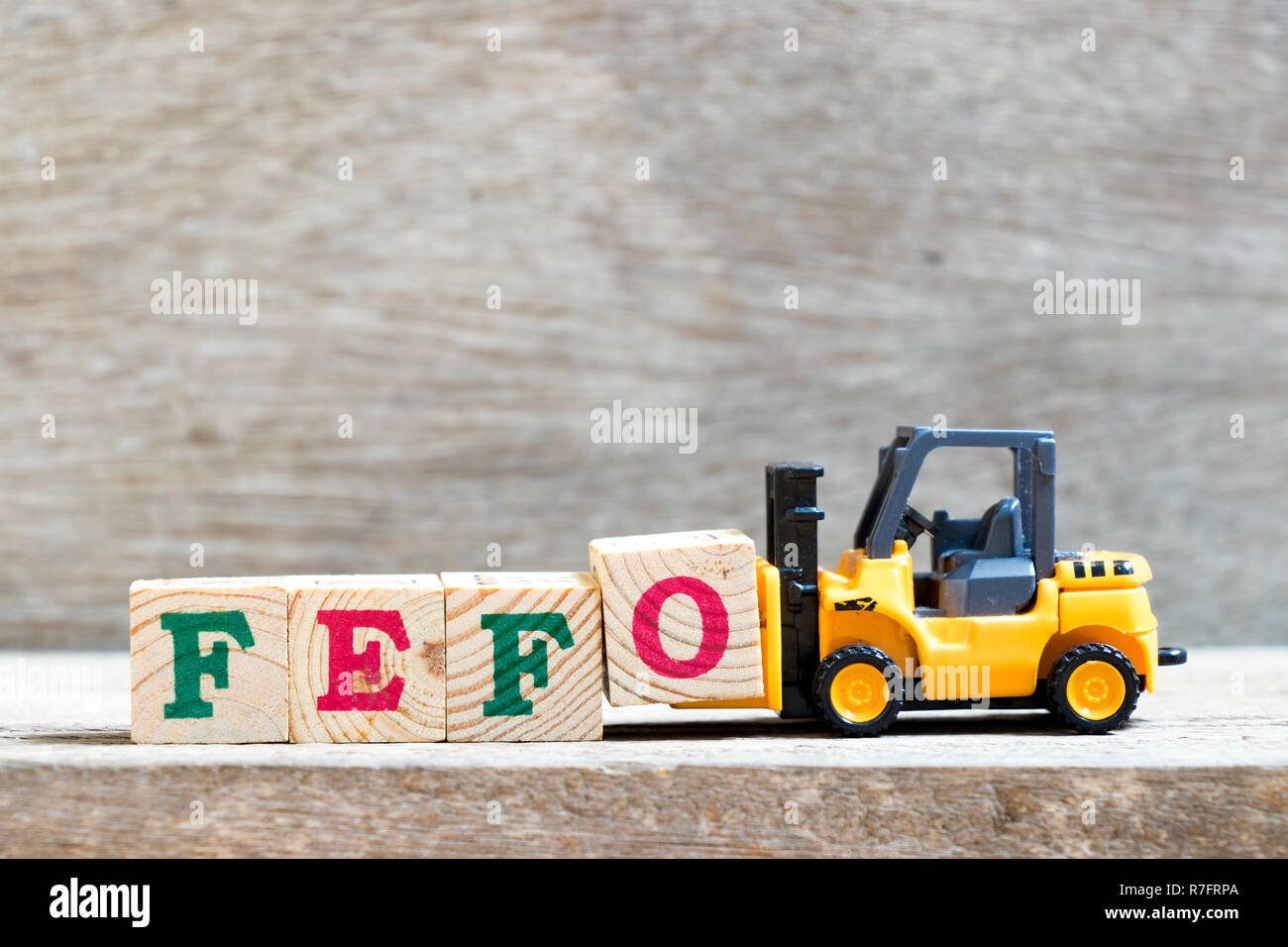 Toy forklift hold letter block O to complete word FEFO (first expired ...