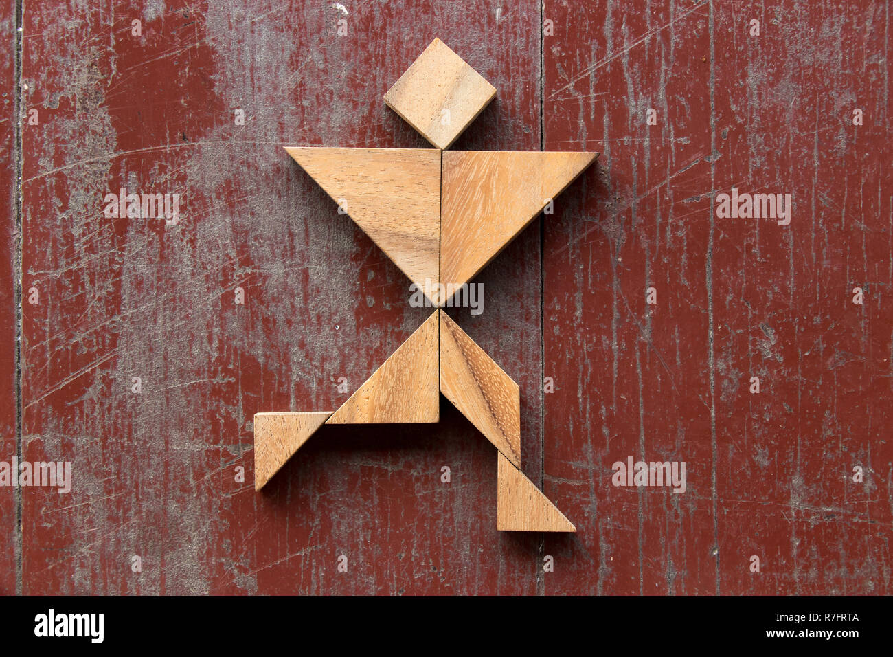Tangram puzzle in joyful man running shape on red old wood background ...