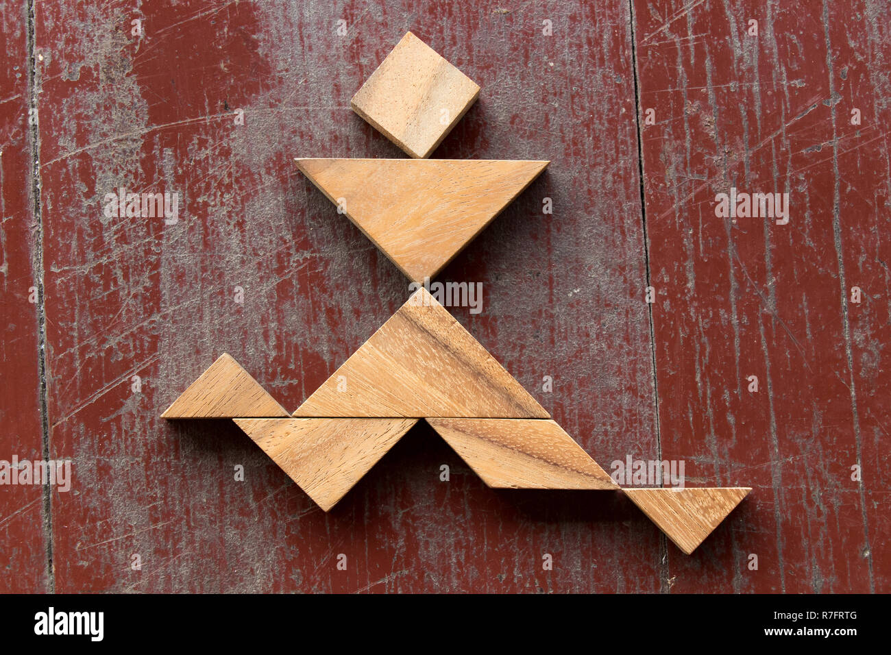 Tangram puzzle in joyful man running shape on red old wood background ...