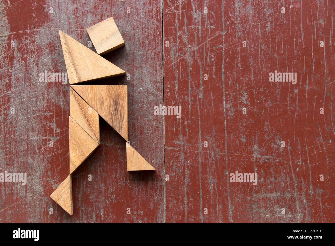 Tangram puzzle in man dancing with fun shape on red old wood background ...