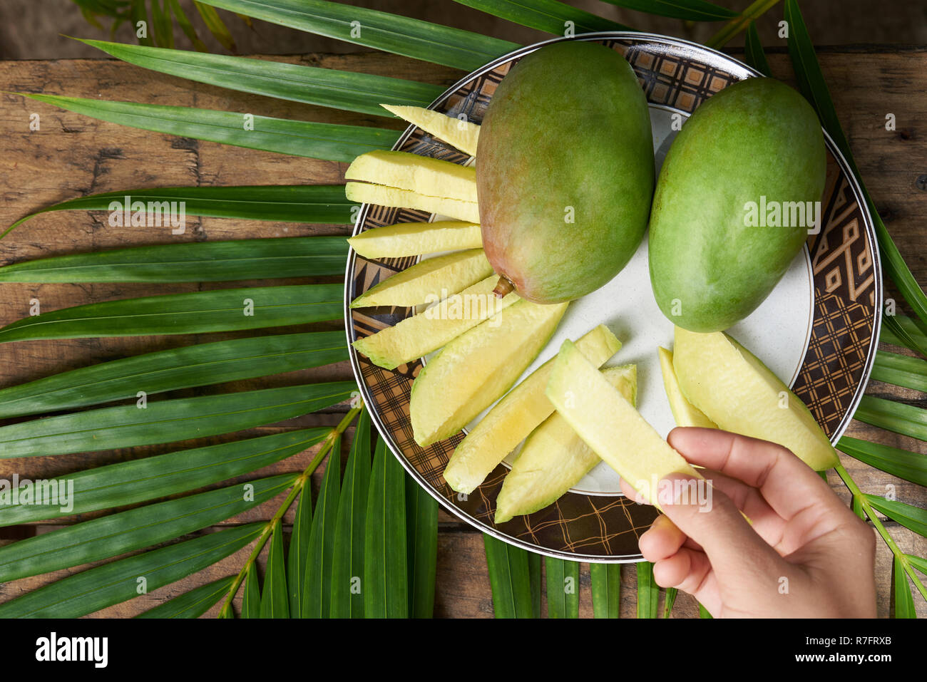 Person holding mango slice outdoor close up above view Stock Photo - Alamy