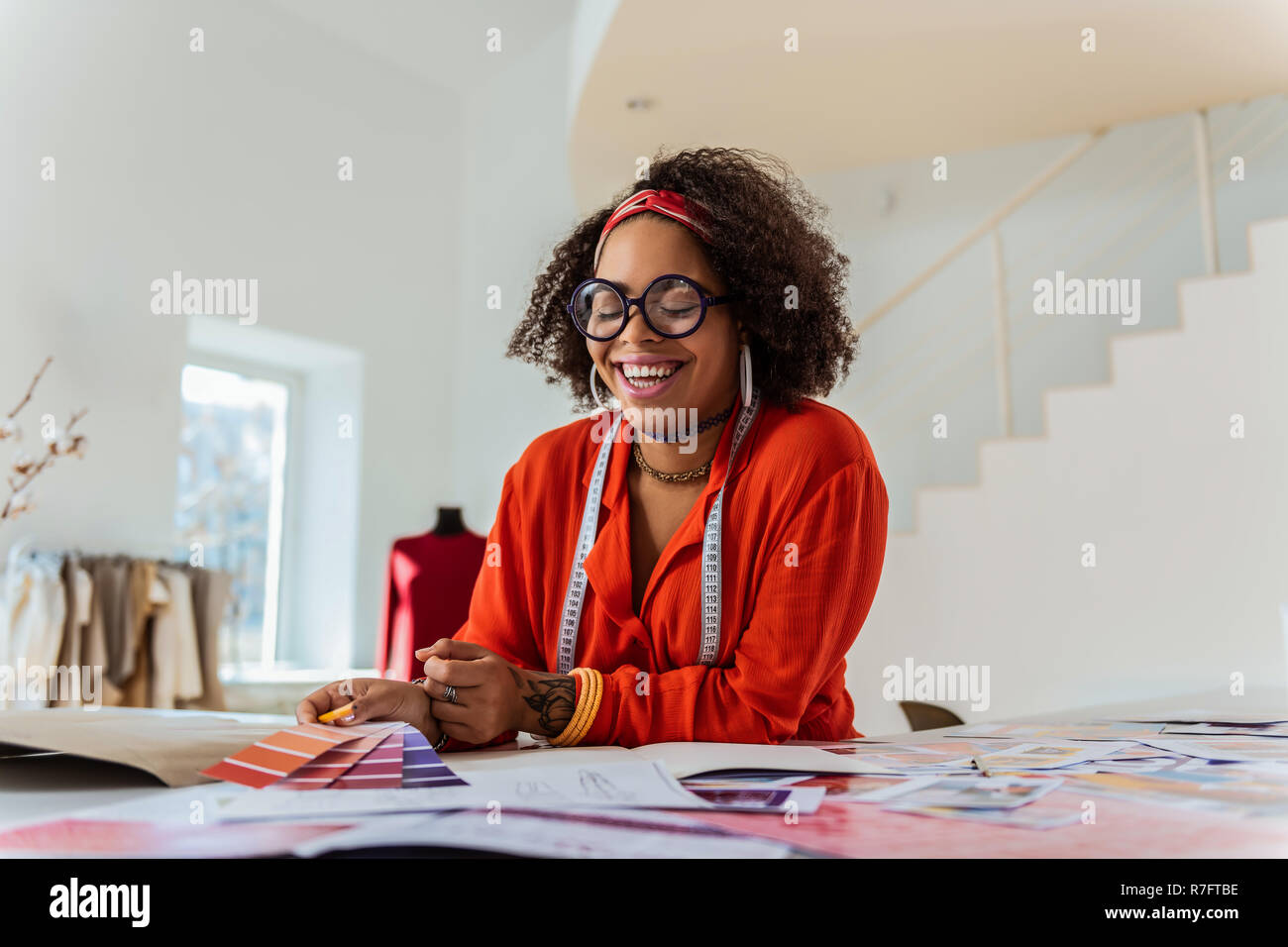 Laughing contented woman sorting out color palette Stock Photo - Alamy