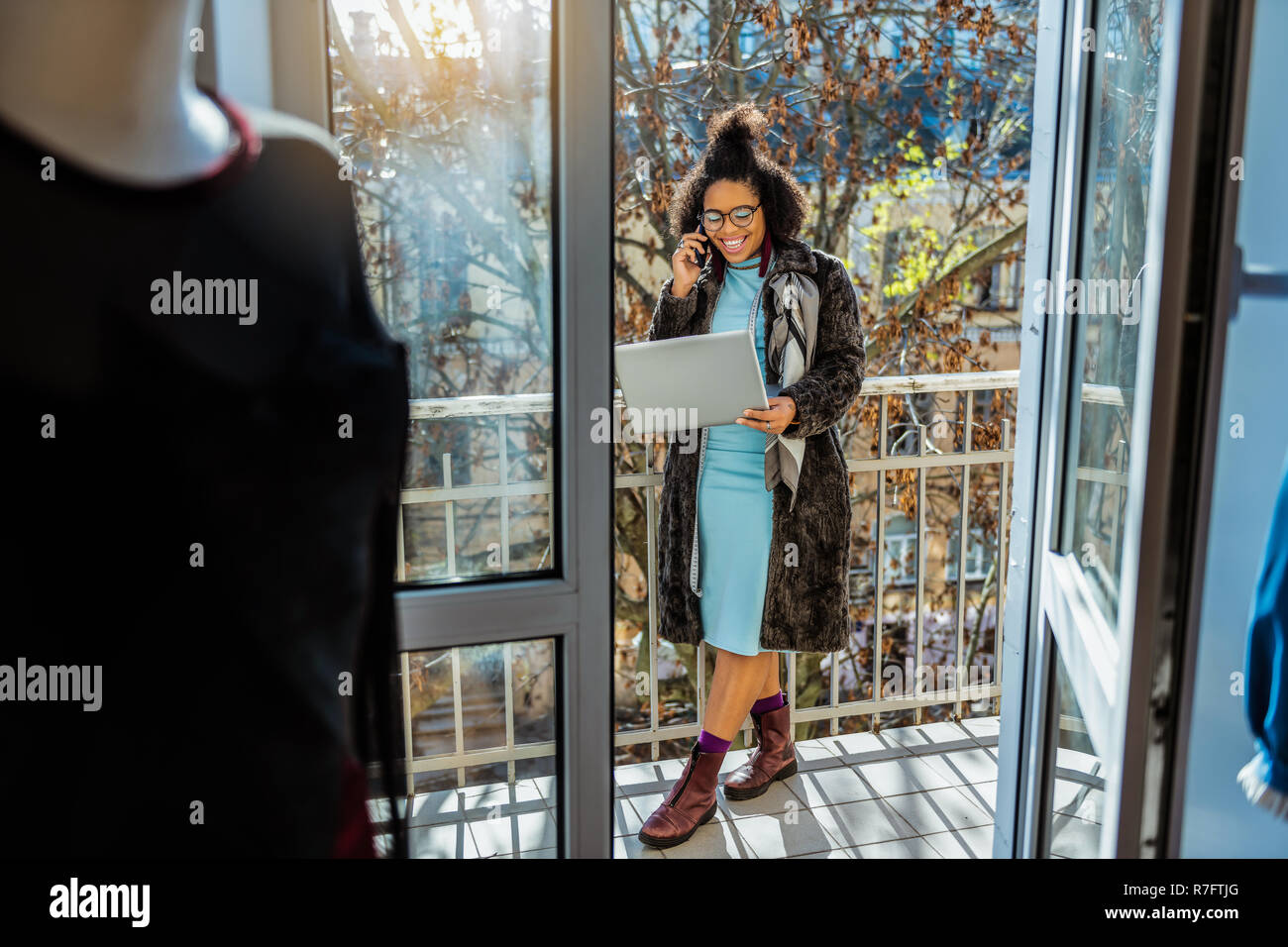 Beaming laughing curly lady being busy and engaged Stock Photo - Alamy