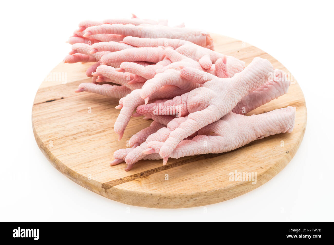 Raw fresh chicken feet on wooden cutting board isolated on white ...
