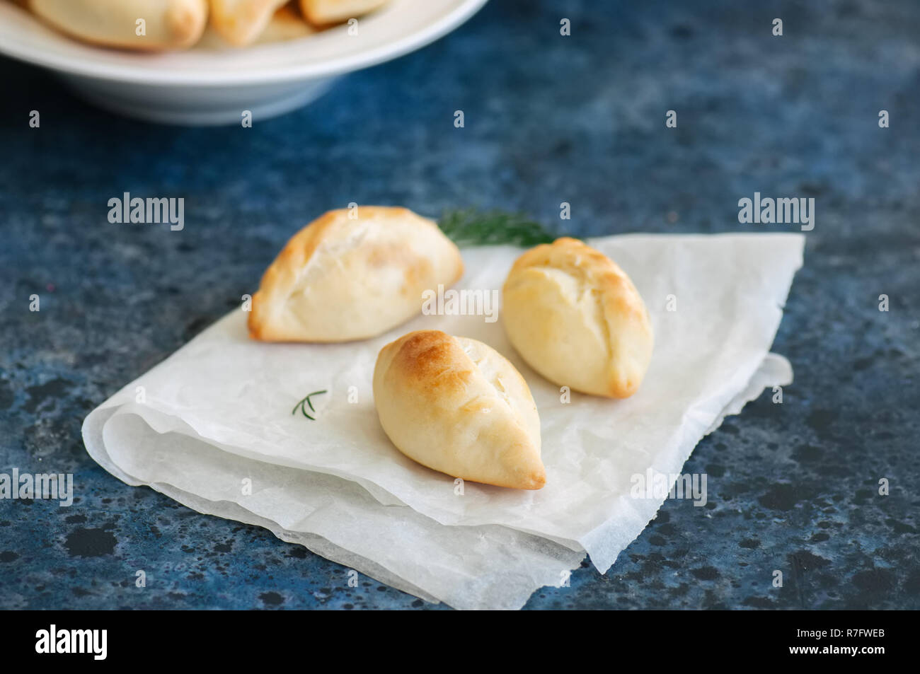 Small mashed potato pasties (hand pies) on a parchment paper. Bl Stock ...