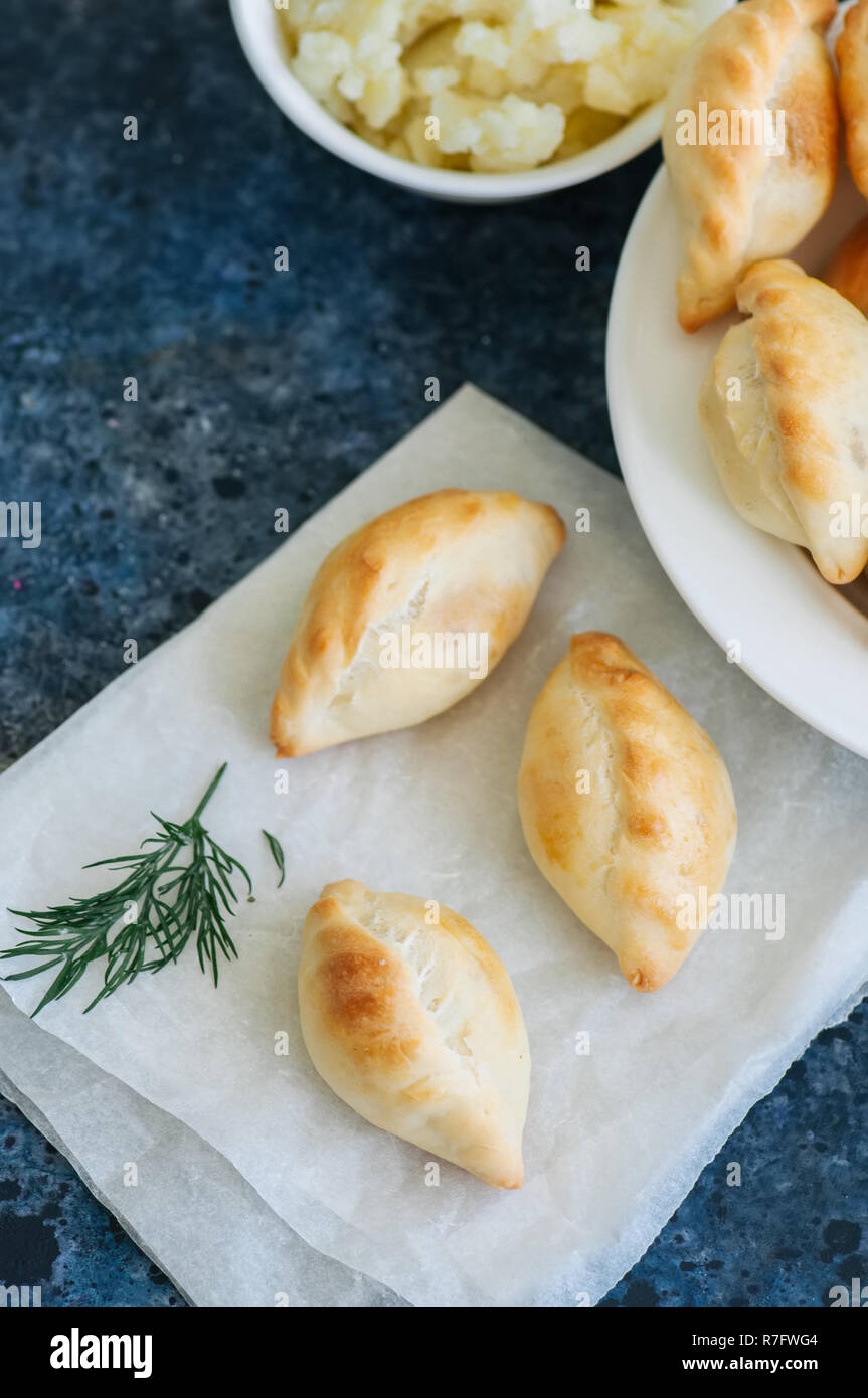 Small mashed potato pasties (hand pies) on a parchment paper. Bl Stock ...
