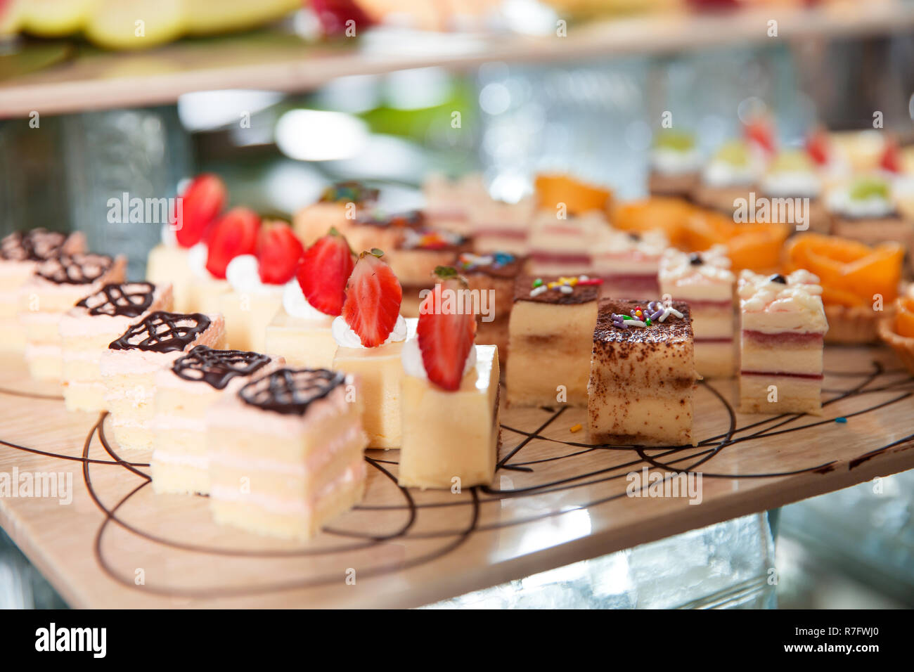 Delicious mini cakes with cream, chocolate and strawberries on buffet ...