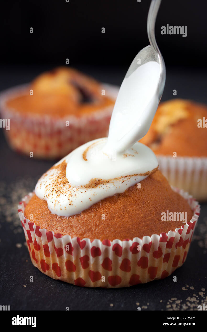 Muffins with cream and spoon Stock Photo - Alamy