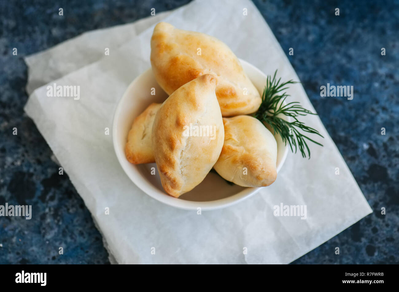 Small mashed potato pasties (hand pies) in a bowl on a parchment Stock ...