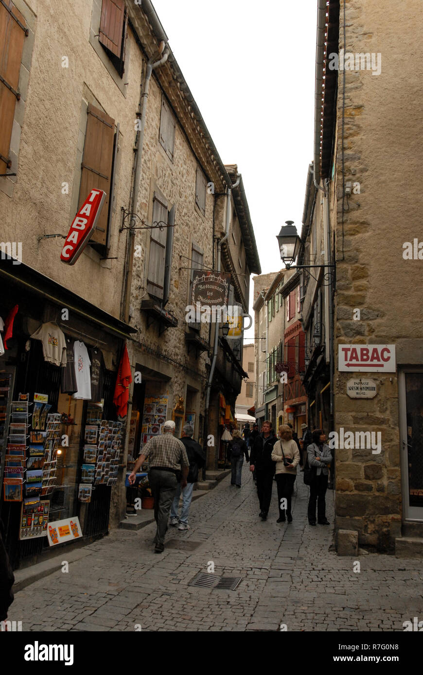 Tourists in a main narrow medieval street lined with tourist shops ...
